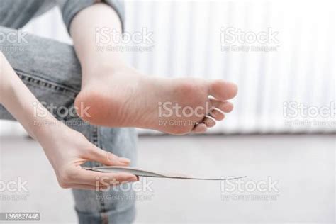 실내에서 정형 외과 깔창을 피팅 여성 가까이 집에서 발 옆에 깔창을 들고 있는 소녀 정형 외과 깔창 풋 케어 배너 플랫 피트 보정 발 질환의 치료 및 예방 발에 대한 스톡