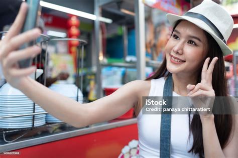 젊은 성인 아시아 식도락가 여자 배낭 여행자는 차이나타운 길거리 음식에서 아시아 디저트를 먹고 있다 여행 소녀들은 방콕의 아름다운 곳에서 즐기고 있습니다 25 29세에 대한