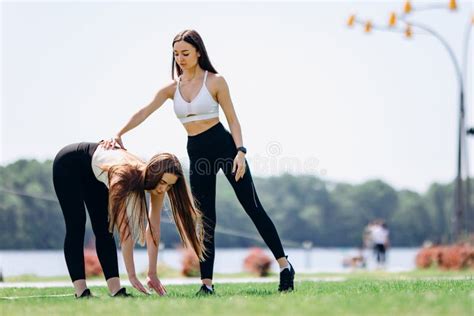 Dos Chicas Hermosas Hacen Ejercicios Al Aire Libre En El Parque Imagen De Archivo Imagen De