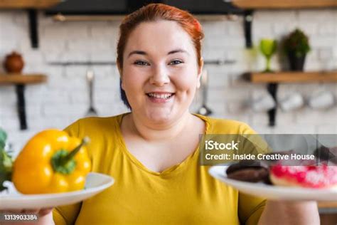 정크 푸드와 건강한 식단 중에서 선택하십시오 야채와 도넛 사이에서 선택하는 젊은 백인 여성 어려운 선택 다이어트 컨셉 25 29