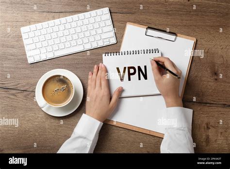 Woman Writing Acronym Vpn In Notebook At Wooden Table Top View Secure