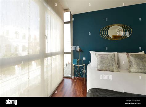 Bedroom With Double Bed With Bright Gray Cushions Indigo Blue Wall