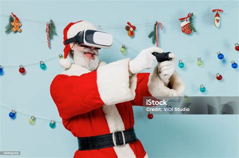 크리스마스 모자 빨간 정장에 오래 된 멋진 산타 클로스 남자 놀이 Pc 게임 조이스틱 콘솔 시계 에 Vr 헤드셋 Pc 가제트 일반 블루 배경 스튜디오 새해 복 많이 받으세요