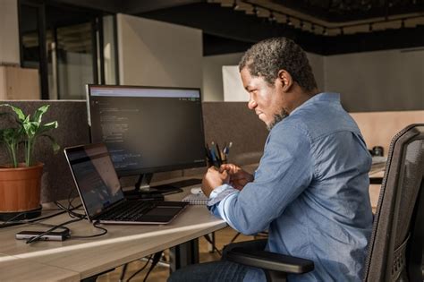 Premium Photo Black Man Writing Lines Of Code On Desktop Pc With Two