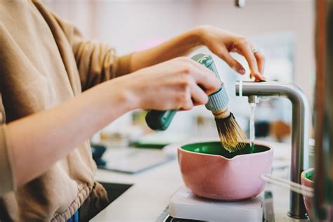 일본의 전통 말차 만들기 과정 바리스타가 말차를 위해 그릇에 물을 넣습니다 커피숍에서 말차 가루를 채찍질하기 위해 현대식 전기 거품기를 들고 있는 여성의 손 건강한 생활