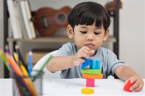 집에서 아시아 의 작은 소년 교육 유치원에 들어가기 전에 아이들의 학습을 개발하는 것은 거실에서 나무 장난감을 가지고 노는 기술을 연습합니다 가정 주부에 대한 스톡 사진 및