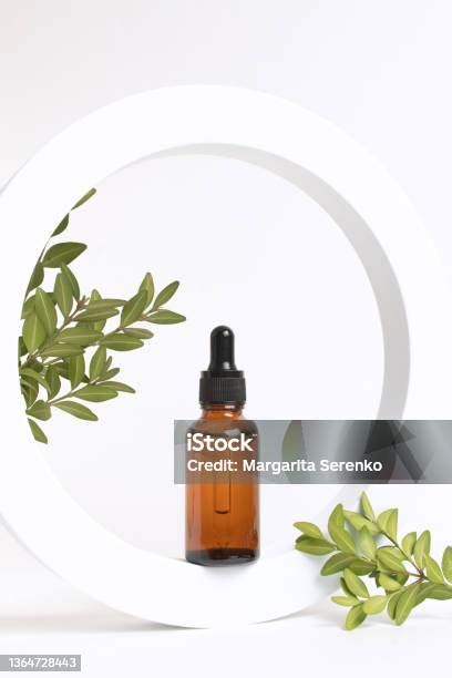 잎이 있는 흰색 배경에 둥근 형태의 호박색 유리 드롭퍼 병 화장품 용기 모형 브랜딩 및 패키징 프레젠테이션을 위한 배경 내츄럴 스킨케어 뷰티 제품 컨셉 0명에 대한 스톡