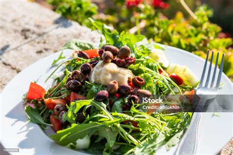 투 스 카 니에서 이탈리아의 외부 정원에 레드 제라늄 꽃에 의해 발코니 테라스에 접시에 올리브와 아 티 초 크와 Arugula 샐러드의 근접 촬영 아루굴라에 대한 스톡 사진