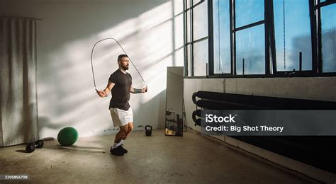 한 남자가 밝은 체육관 환경에서 체력을 향상시키기 위해 줄넘기를 하고 있습니다 동기 부여에 대한 스톡 사진 및 기타 이미지 동기 부여 땀 마음이 젊은 Istock