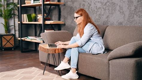 그녀의 노트북 앞에 사무실에서 소파에 앉아 일하는 매력적인 소녀 검은색에 대한 스톡 사진 및 기타 이미지 검은색 노트북 노트북 사용하기 Istock