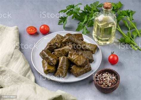 돌마 올리브 오일 토마토 및 후추로 밝은 배경에 신선한 허브가 있는 파란색 접시에 채워진 포도 잎 0명에 대한 스톡 사진 및 기타 이미지 Istock