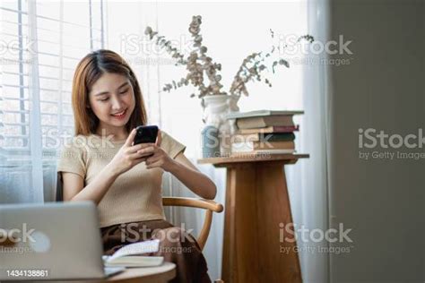 커피 숍에서 스마트 폰과 노트북을 가지고 노는 아시아 여성 인터넷 서핑 채팅 블로깅을하는 젊은 여성 전화를 들고 화면을 보는 여자 비즈니스 캐주얼에 대한 스톡 사진 및 기타