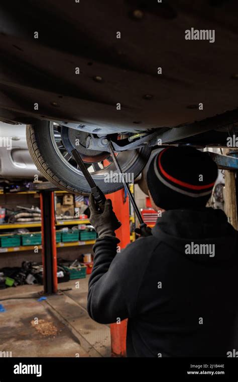 A Photo Of Man Under Car Fixing The Wheel Stock Photo Alamy