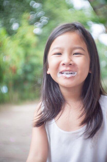 Premium Photo Portrait Of Smiling Girl Standing Outdoors
