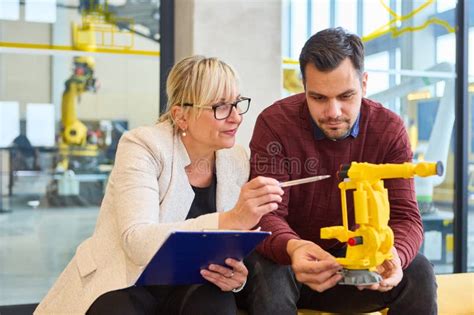 Engineers Discussing Robot Design In A Lab For Industrial Automation