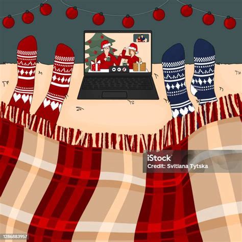 사람들은 니트 빨간색과 파란색 양말침대에 있습니다 그들은 노트북에 보고 그것은 크리스마스 시간에 친구 및 가족과 화상 통화