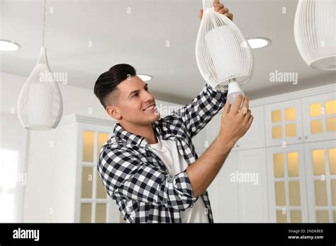 Man Changing Light Bulb In Lamp At Home Stock Photo Alamy