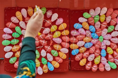 Premium Photo Cropped Image Of Person Throwing Dart On Colorful Balloons