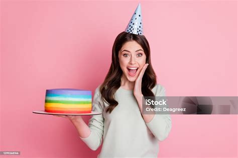 놀라운 펑키 한 레이디 손의 초상화 뺨 오픈 입 홀드 케이크 이벤트 모자 파스텔 핑크 배경에 고립 갈색 머리에 대한 스톡 사진 및 기타 이미지 Istock