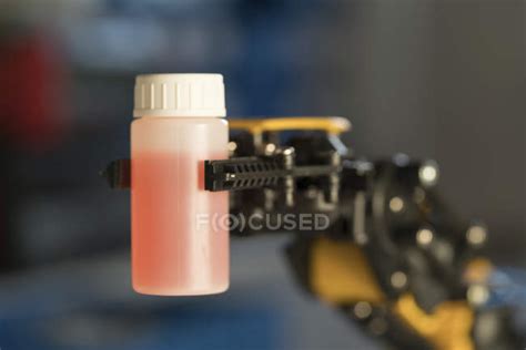 Robotic Arm Holding Bottle With Liquid Cropped Close Up Stock Photo