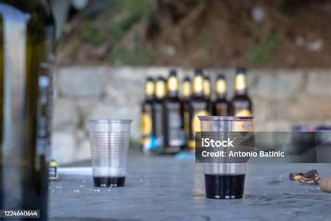 와인 의 두 거의 빈 컵 배경에 흐린 맥주 병 공원에서 공공 음주의 쓰레기와 쓰레기의 유적 공공 장소에서 술을 마시는 청소년과 음주의 개념 쓰레기에 대한 스톡 사진 및 기타