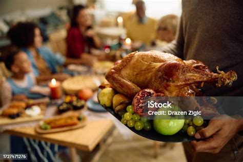 식당에서 추수감사절 칠면조를 가족에게 제공하는 남자의 클로즈업 11월에 대한 스톡 사진 및 기타 이미지 11월 공휴일 구이 Istock