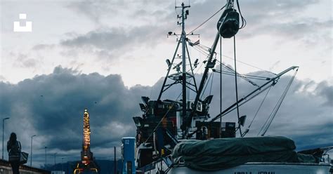 하얗고 푸른 구름 낀 하늘 아래 주차된 배 옆 통로를 걷는 여자 사진 Unsplash의 무료 리예카 이미지