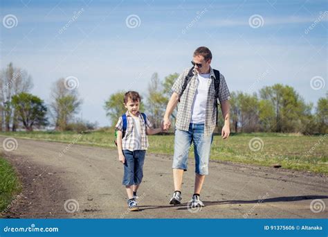 Pai E Filho Que Andam Na Estrada No Tempo Do Dia Foto De Stock Imagem