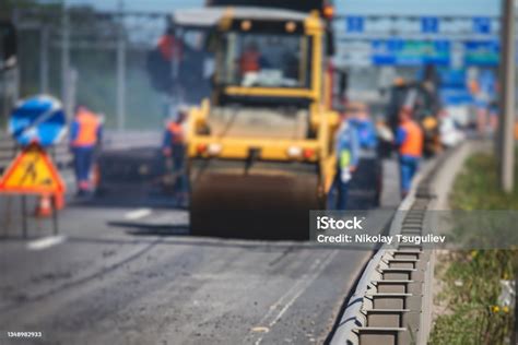 도로 건설 및 수리 작업 중 아스팔트 파버 기계 및 증기 도로 롤러 새로운 도로 건설 현장에서 일하는 근로자 여름에 레이어를