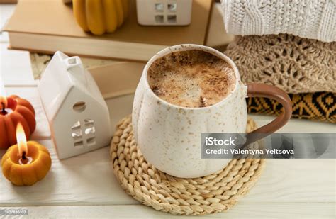 가을 작곡 뜨거운 커피 한 잔 장식용 작은 집 호박 양초 책 나무 테이블에 따뜻한 스웨터 계절에 따라 따뜻한 아침 커피 아늑한 인테리어 장식 가을에 대한 스톡 사진 및 기타
