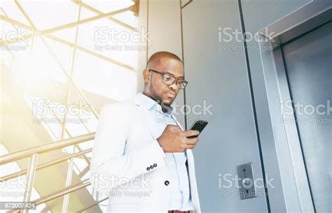 현대 사무실 건물에서 걷고 있는 동안 스마트폰 사용 하는 안경에 행복 한 미소 아프리카 사업가의 단일 초상화 남자에 대한 스톡 사진 및 기타 이미지 Istock