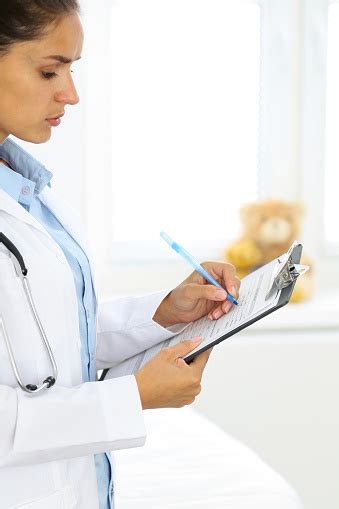 클로즈업 병원에서 똑바로 서 있는 동안 클립보드에 의료 양식을 작성 여성 의사의 건강관리와 의술에 대한 스톡 사진 및 기타 이미지 건강관리와 의술 공란 노트 Istock