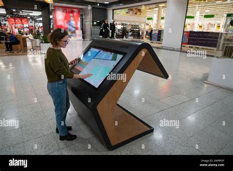 Woman With Phone Uses Self Service Kiosk In The Shopping Mall Stock Photo Alamy