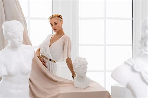 그리스 여신 측면 보기로 포즈를 취하는 여자 무료 사진