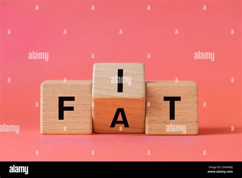 Hand Is Turning Wooden Block And Changes The Word FAT To FIT