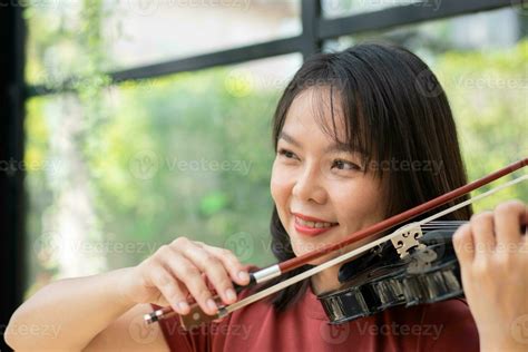 An Attractive Woman Learning Musician Plays The Violin At Home