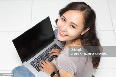 흰색 배경과 복사 공간에 노트북을 사용하여 회색 캐주얼 셔츠를 입고 아름다운 아시아 여성 귀여운 아시아 여자 앉아 에 이 바닥 방 휴식 용 작업 부터 홈 컨셉 25 29세에
