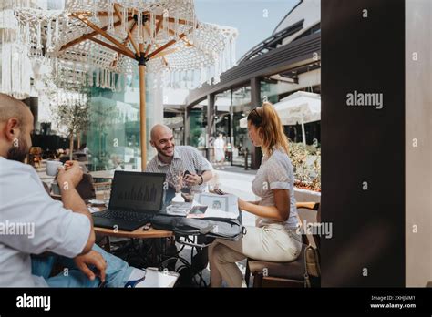 Startup Team In Business Meeting Discussing Brainstorming And Strategizing In An Outdoor Cafe