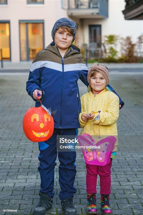 어린 어린 소녀와 학교 소년은 세인트 마틴 행렬을 위해 촛불을 들고 스스로 만든 등불을 들고 있다 두 명의 건강한 아이들이 유치원에서 가족 퍼레이드에 만족합니다 독일 전통