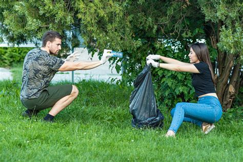 지역 공원에서 쓰레기를 수거하는 자원봉사자 자연에서 쓰레기를 수집합니다 에코 자원봉사 행복한 부부는 이웃이 공원에서 쓰레기를 수거하는 것을 도와줍니다 2명에 대한 스톡 사진