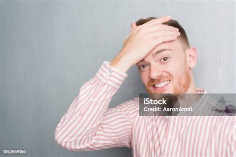 젊은 빨강 머리 남자 머리 수치심과 깜짝 얼굴로 충격된에 손으로 강조 하는 회색 그런 지 벽에 분노와 좌절 두려워 하 고 실수에