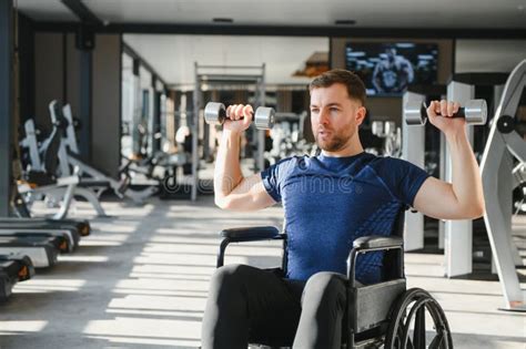 Man With Disability Lifting Weights In A Wheelchair At The Gym Stock