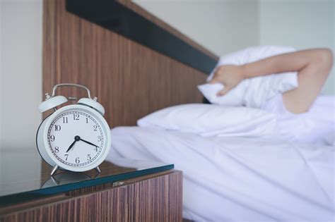 한 남자가 침대에서 알람 시계의 소음에서 베개로 머리와 귀를 닫습니다 걱정하는에 대한 스톡 사진 및 기타 이미지 걱정하는