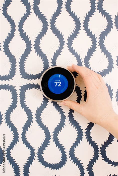 Hand Of Woman Adjusting Modern Smart Thermostat Stock Photo Adobe Stock