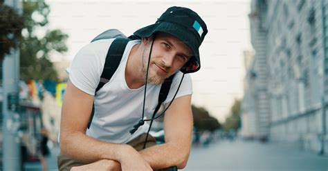 유럽의 오래된 도시 야외에서 자전거를 타고 일부러 카메라를 가까이서 바라보는 웃는 남자 자전거 손잡이 바에 손을 꼬고 있는 남성 초상화 사진 Unsplash의 사진술 이미지