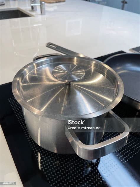 현대 유도 세라믹 호브에 스테인레스 스틸 냄비의 클로즈업 이미지 검은 주방 밥솥 스토브 온도 전원을위한 터치 제어 노브전기 핫 플레이트 영역 흰색 복합 화강암 조리대 싱크대