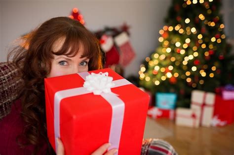 Premium Photo Redhead Showing Gift On The Armchair At Christmas