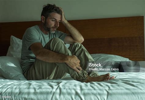 매력적인 우울 하 고 화가 남자 에 홈 침실 3040대 잘생긴 남자의 극적인 라이프스타일 초상화가 침대에 앉아 걱정과 절망적인