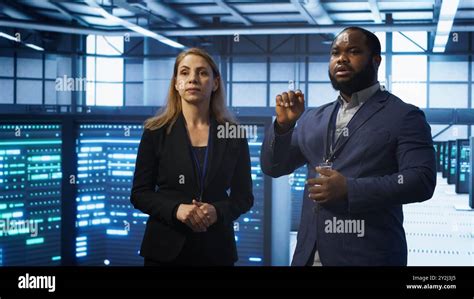 Teamworking Technicians In High Tech Data Center Workspace Looking At