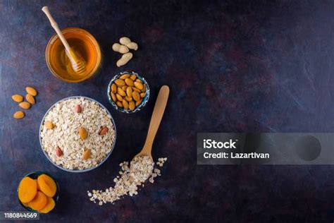 건강한 아침 식사를 위한 오트밀과 견과류 그릇과 꿀에 귀리 조각 건조 오트밀 아몬드 말린 살구 식품 컨셉 0명에 대한 스톡 사진